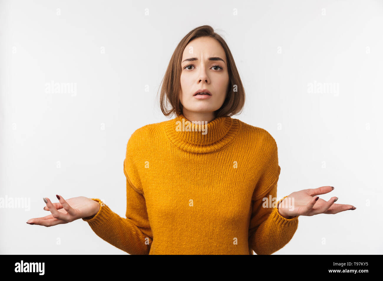 Attractive confused young woman standing isolated over white background ...