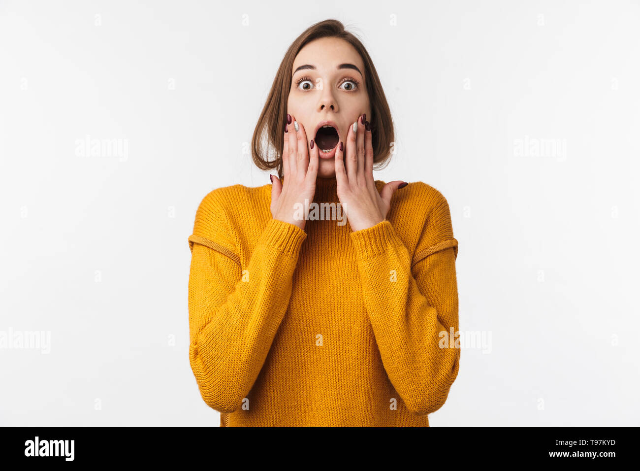 Attractive shocked young woman standing isolated over white background ...
