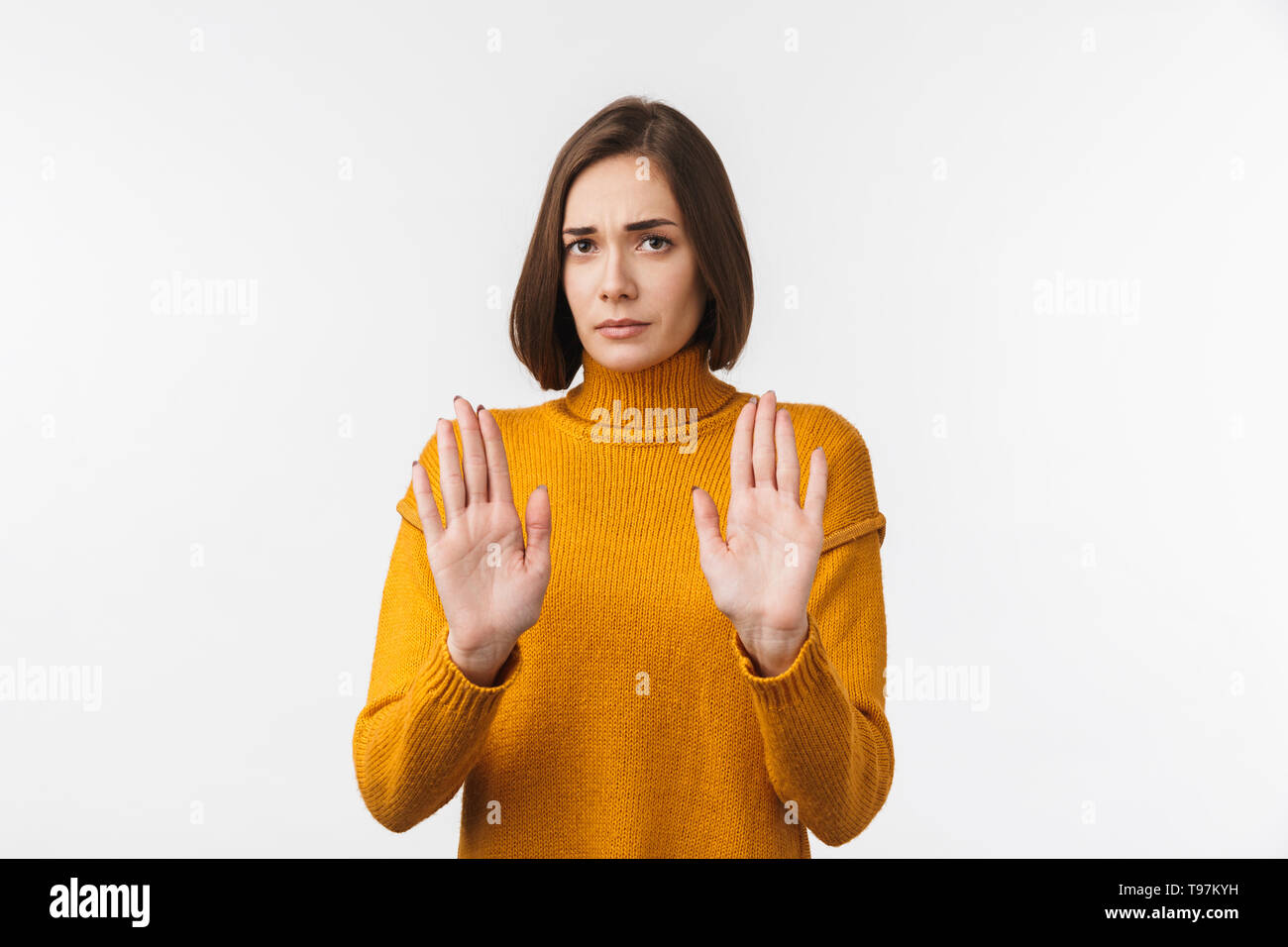 Serious young girl standing isolated over white background, showing ...