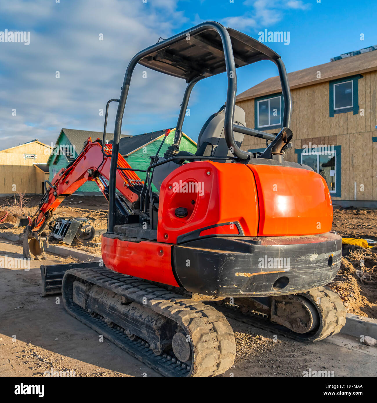 Square Red excavator on a construction site for new homes against ...