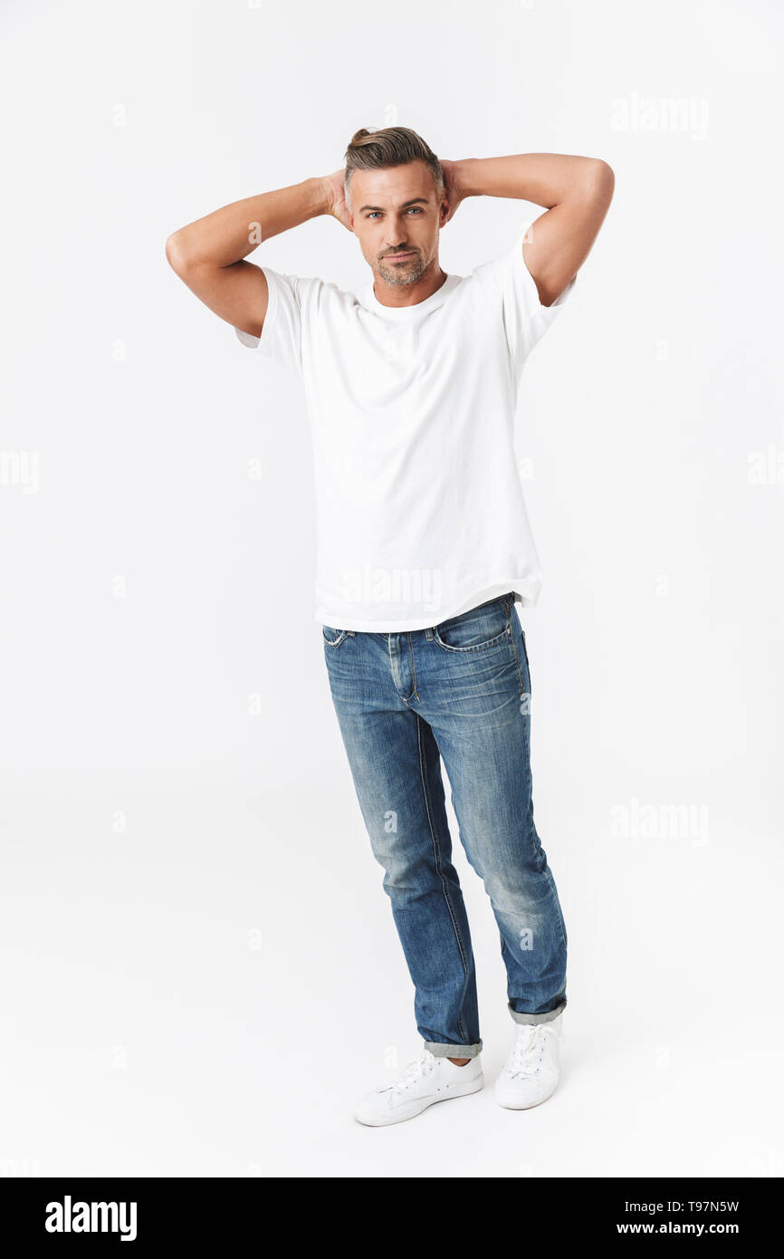 Full length of a casual handsome man wearing t-shirt standing isolated ...
