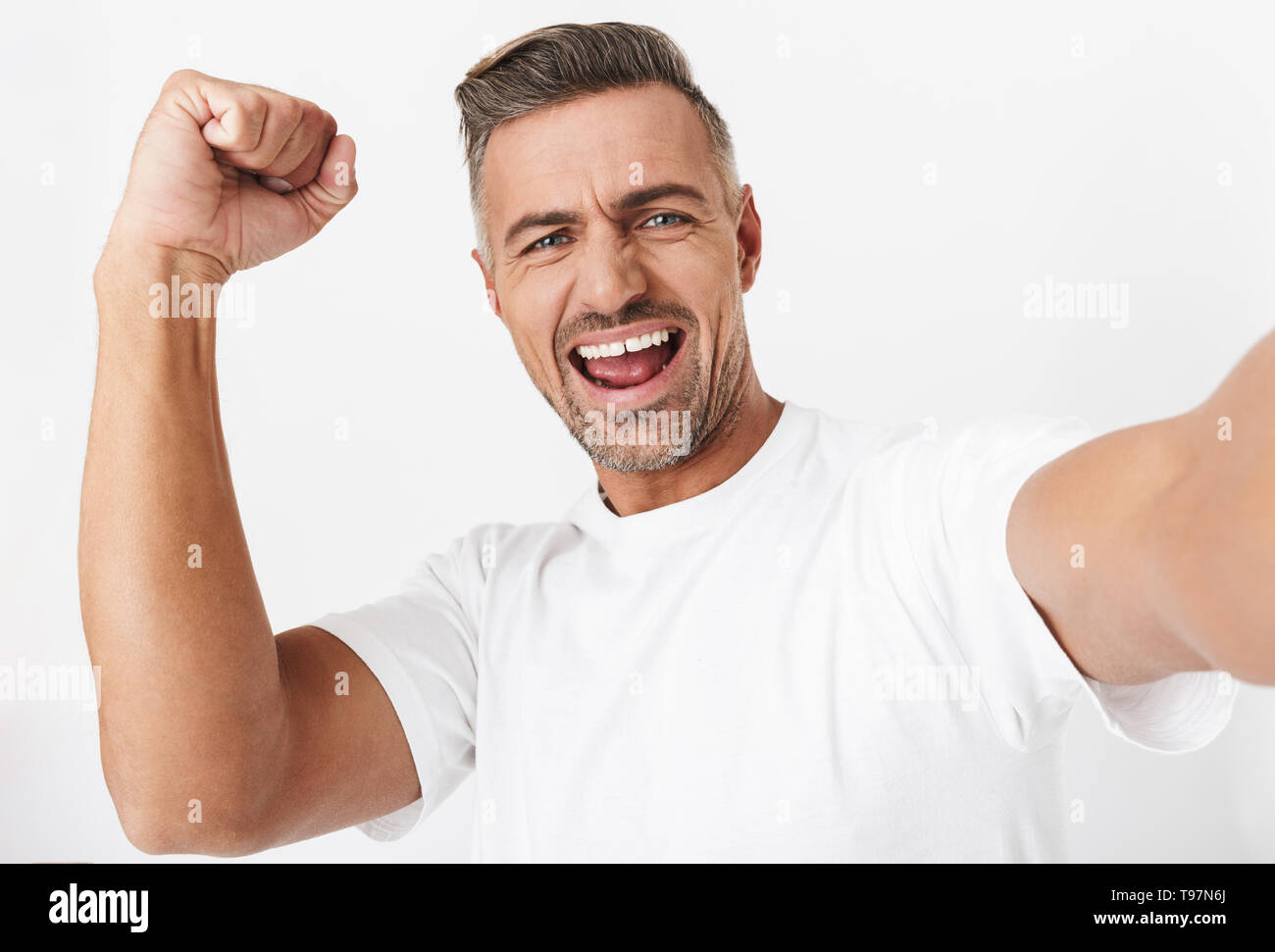 Image closeup of ecstatic man 30s wearing casual t-shirt looking on ...