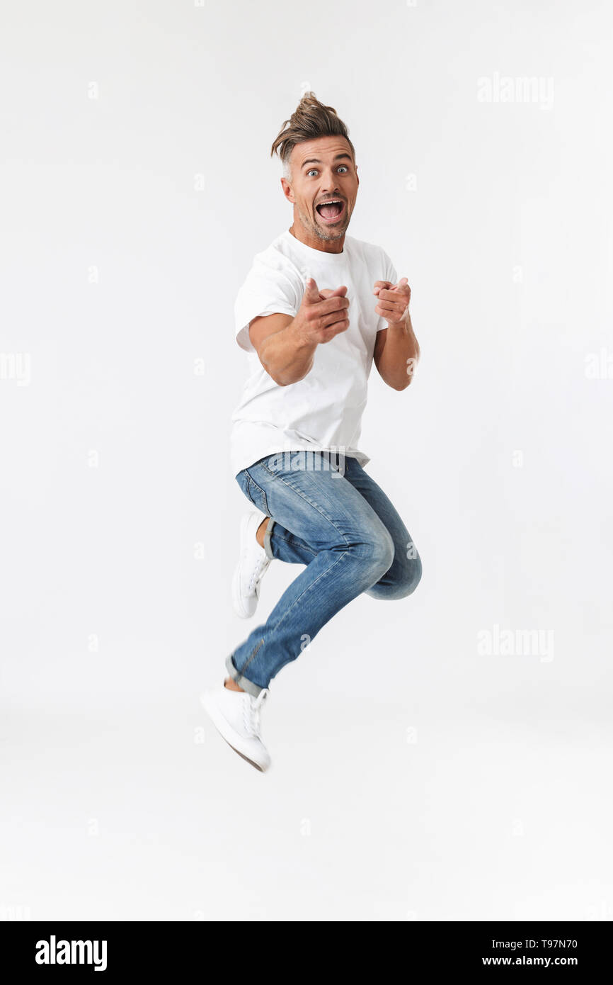 Full length portrait of a handsome casual man jumping isolated over ...