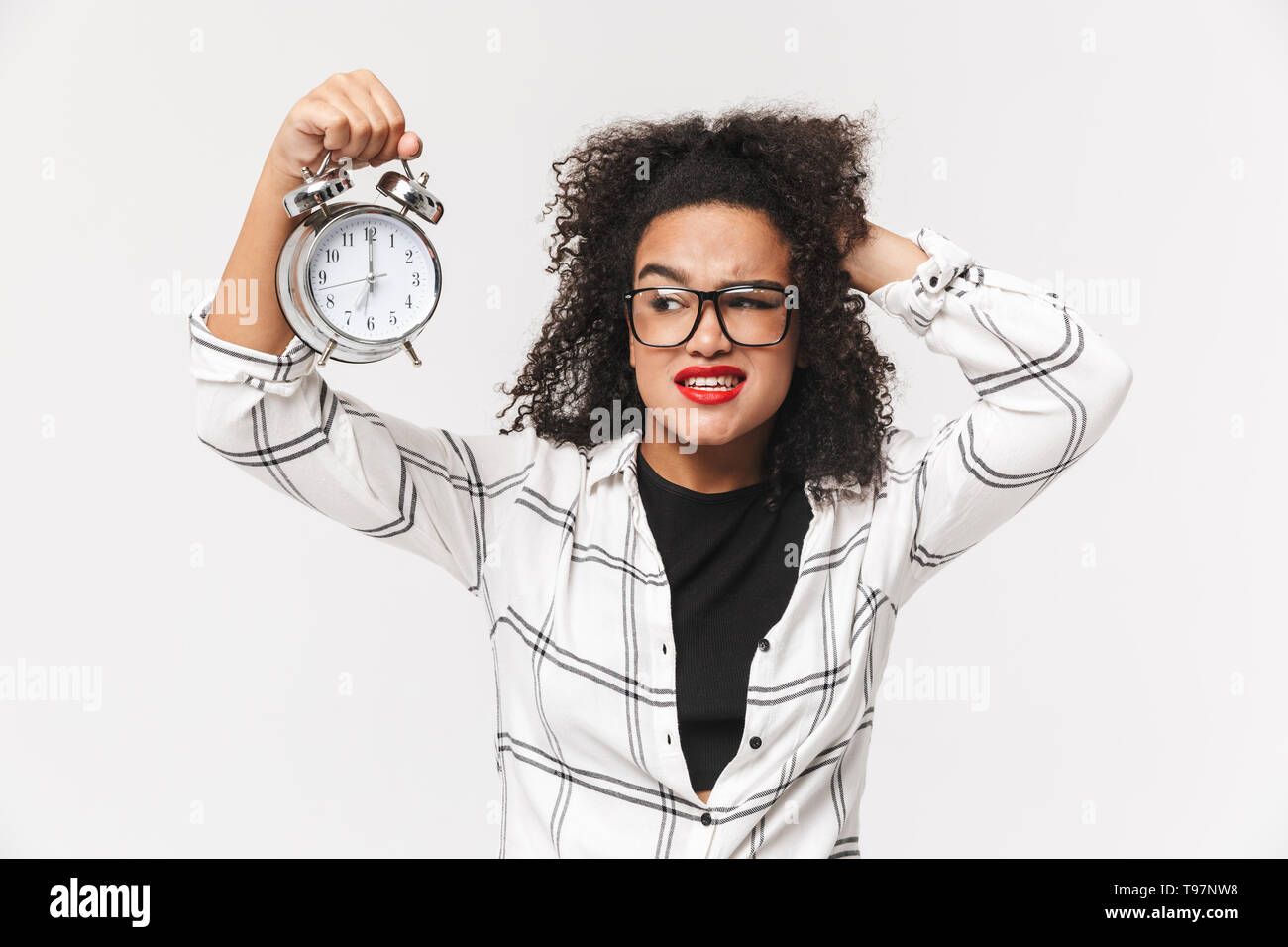 Portrait of a shocked confused african woman standing isolated over ...