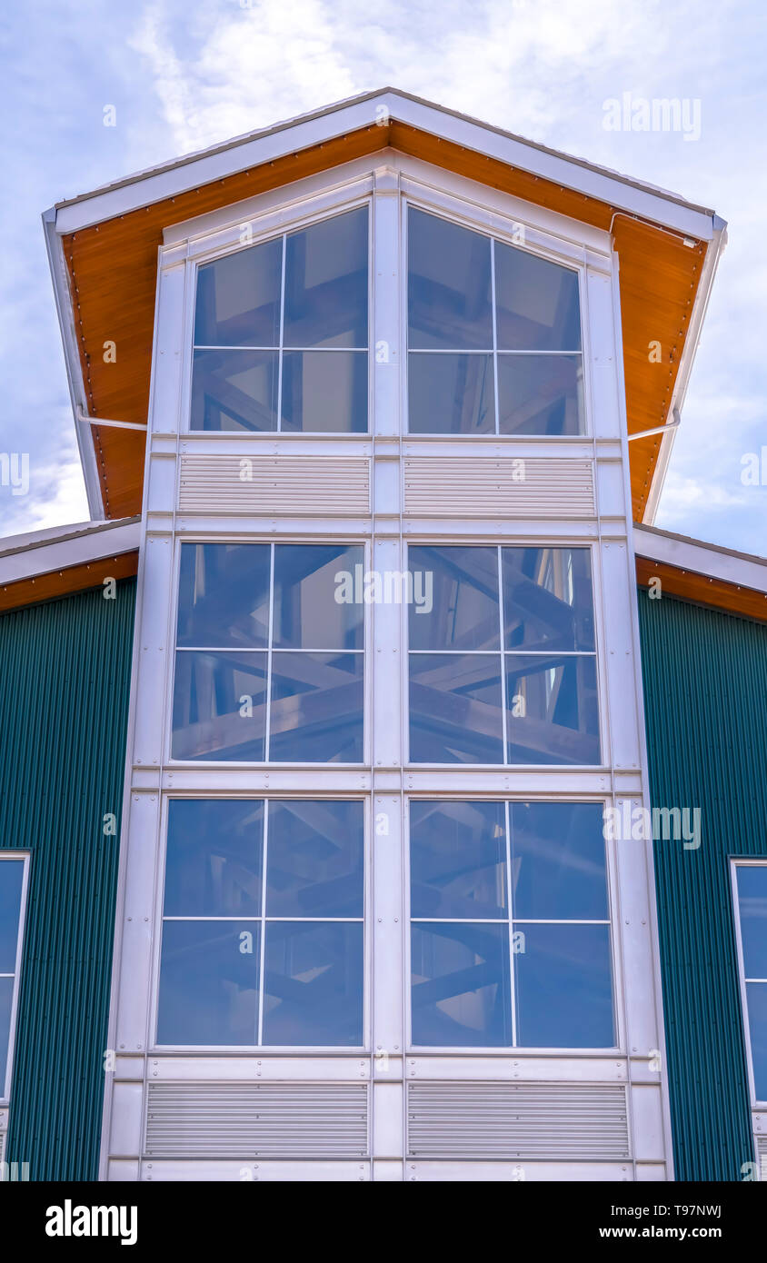 Large glass window of a building with a bright and cloudy blue sky ...