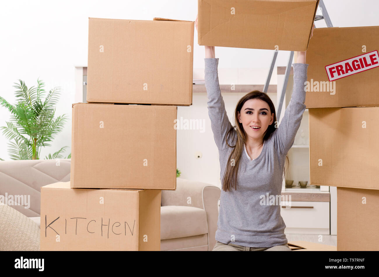 Young beautiful woman moving to new flat Stock Photo - Alamy