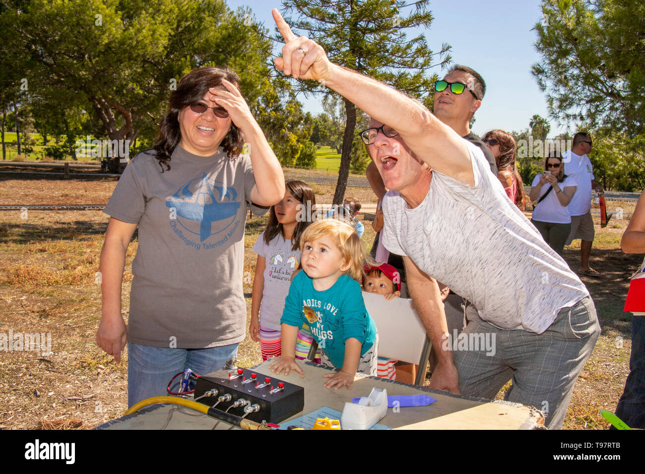 Families watch in amazement as paper air rockets powered by an air ...