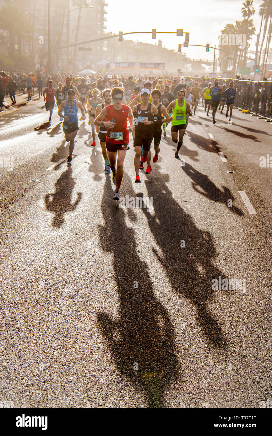 Half marathon runners throw long shadows as they leave the starting ...