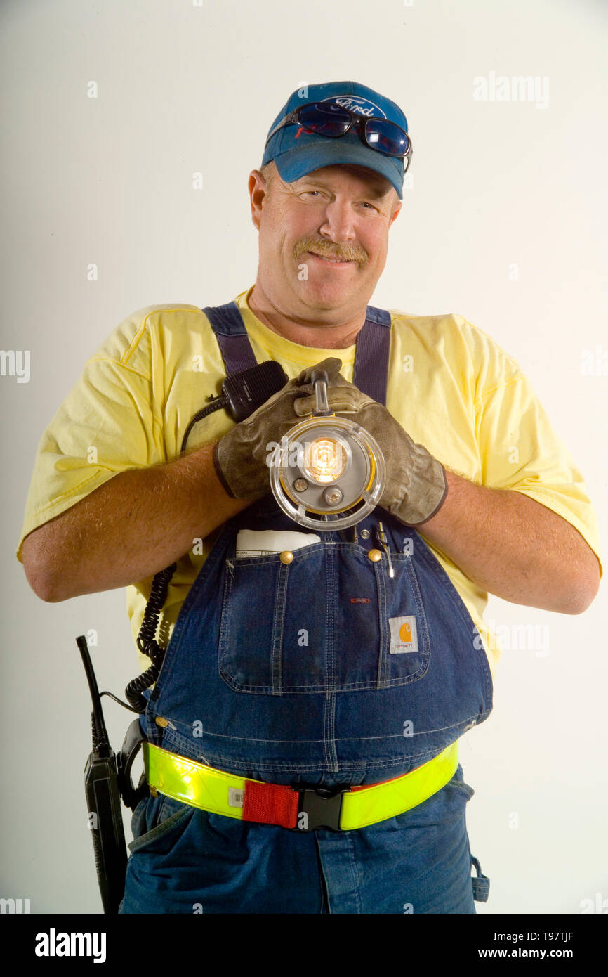 Carrying a flashlight, a railroad yard workman poses playfully at the ...