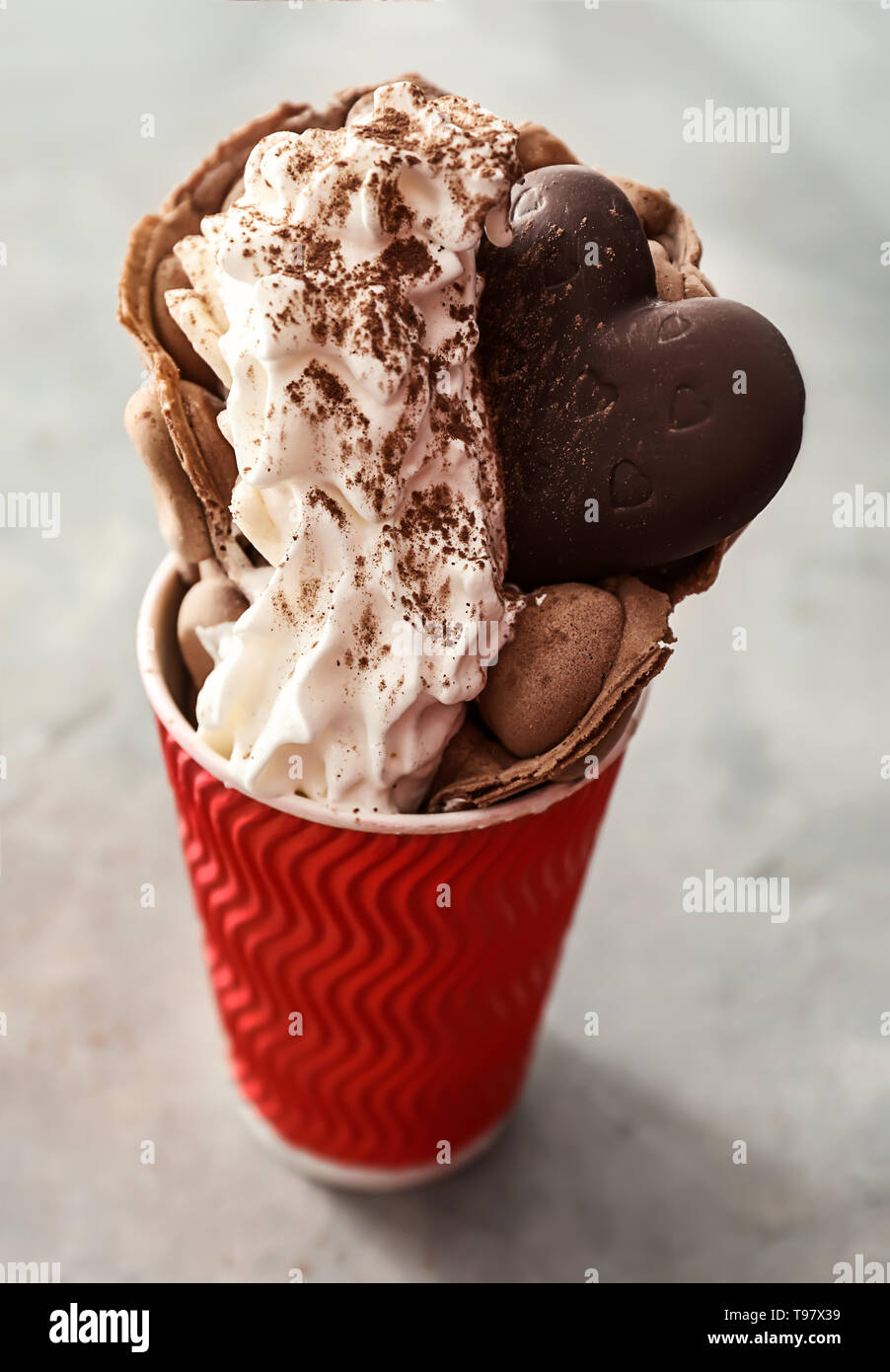 Delicious bubble waffle in cup on grey table Stock Photo - Alamy