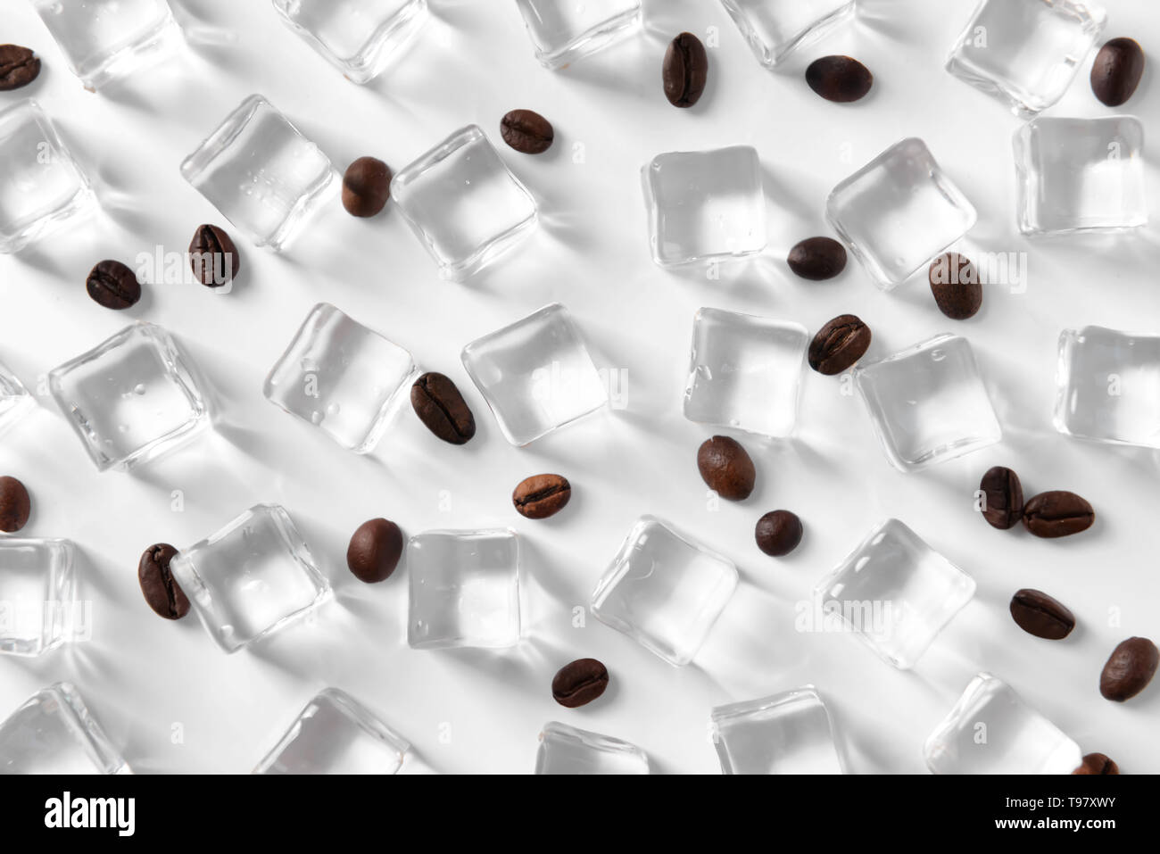 Ice cubes and coffee beans on white background Stock Photo - Alamy
