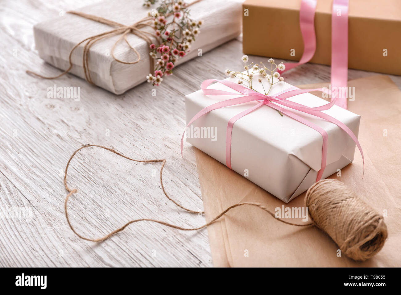 Beautiful gift boxes with threads on light table Stock Photo - Alamy