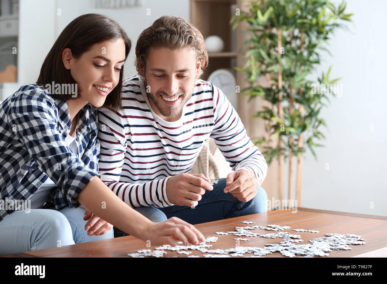 Young people doing jigsaw puzzle hi-res stock photography and images ...
