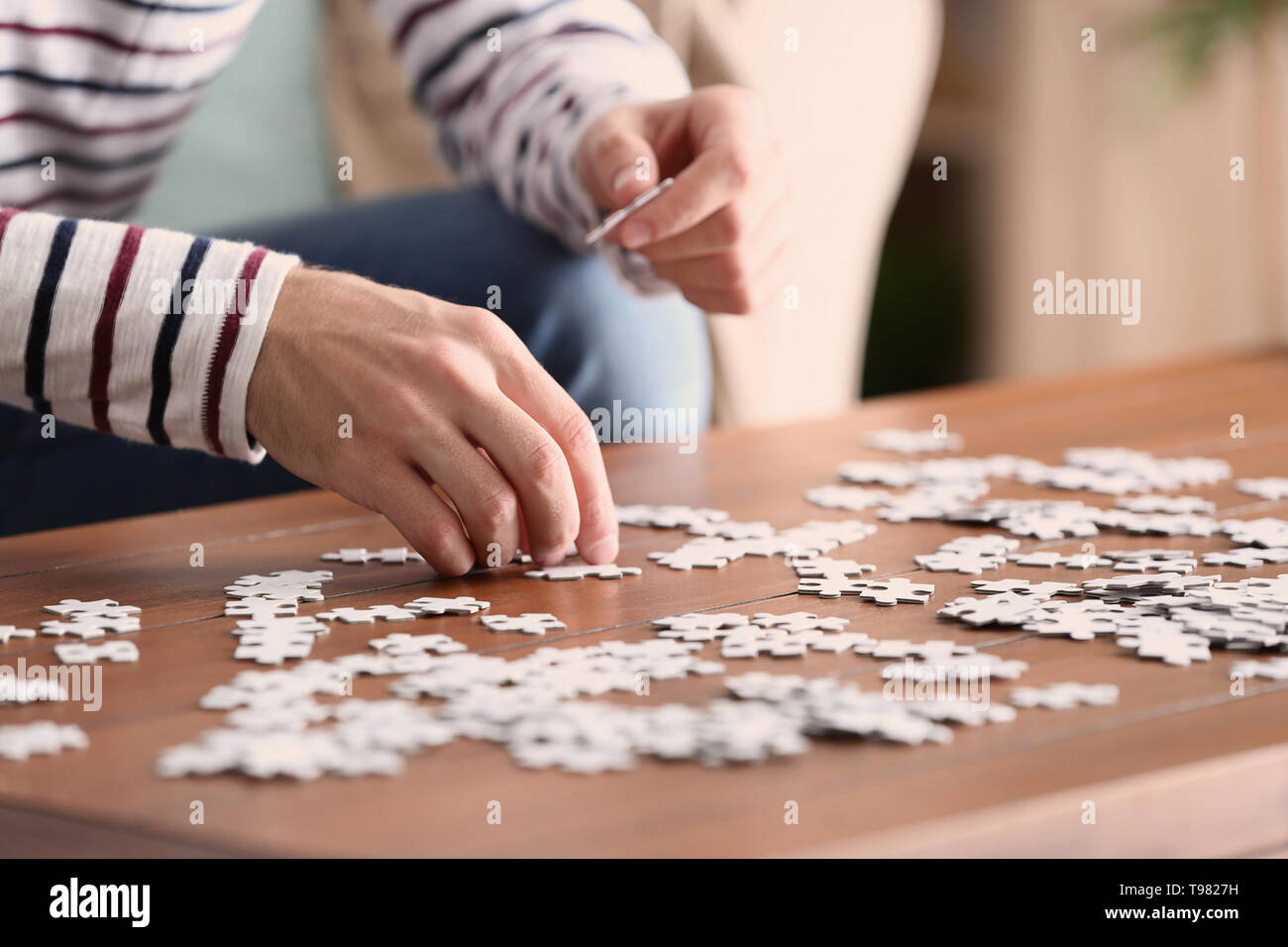 Young people doing jigsaw puzzle hi-res stock photography and images ...