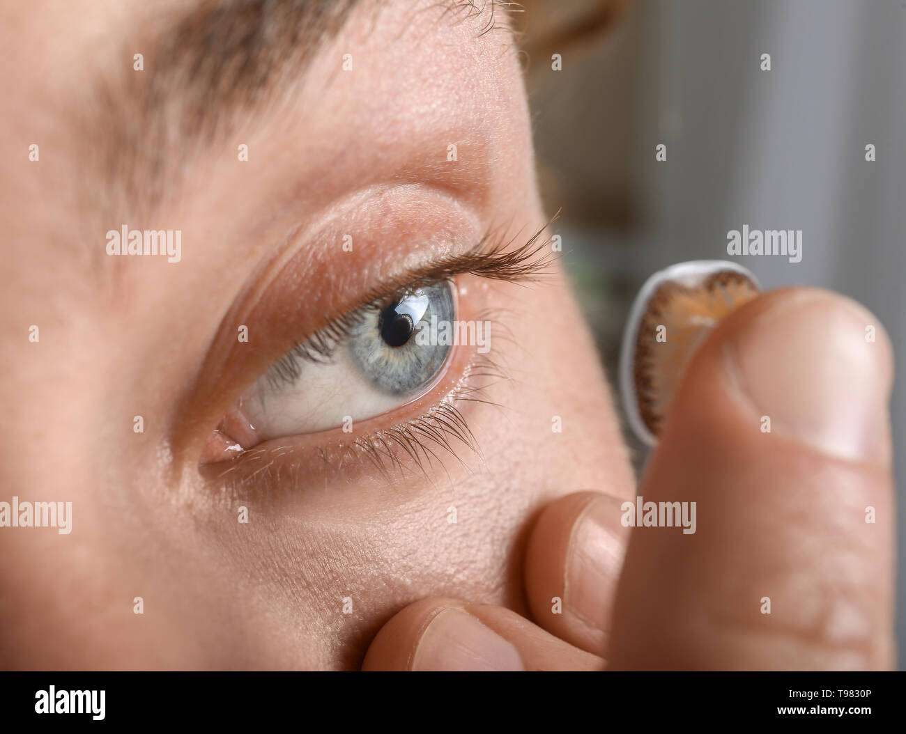 Young man putting lens in his eye, closeup Stock Photo - Alamy