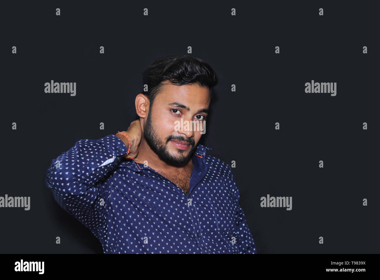 portrait of a handsome smart young man model with black background ...