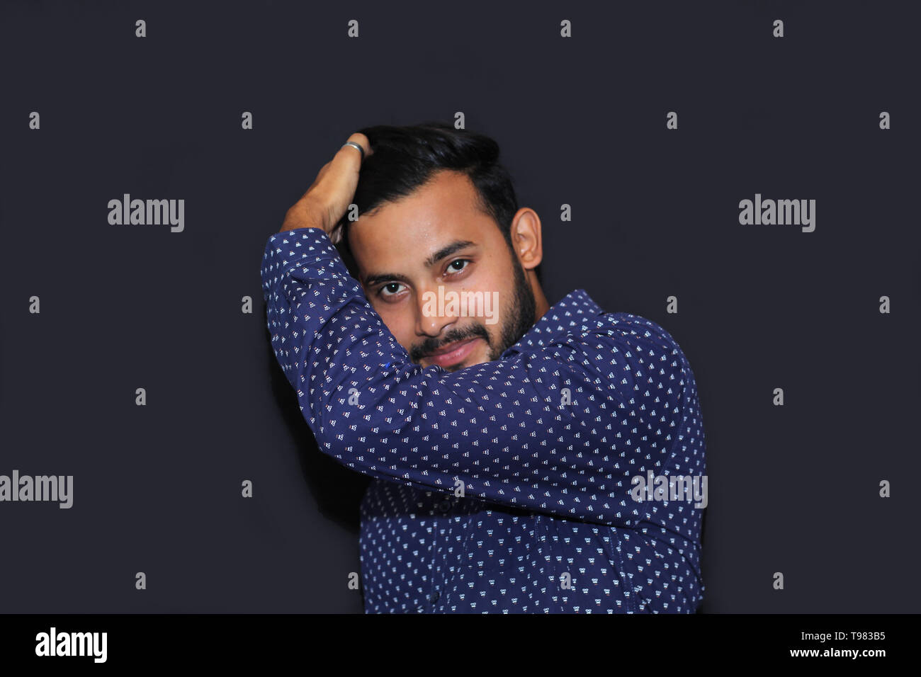 Portrait of a happy young man model holding his hair with a black ...