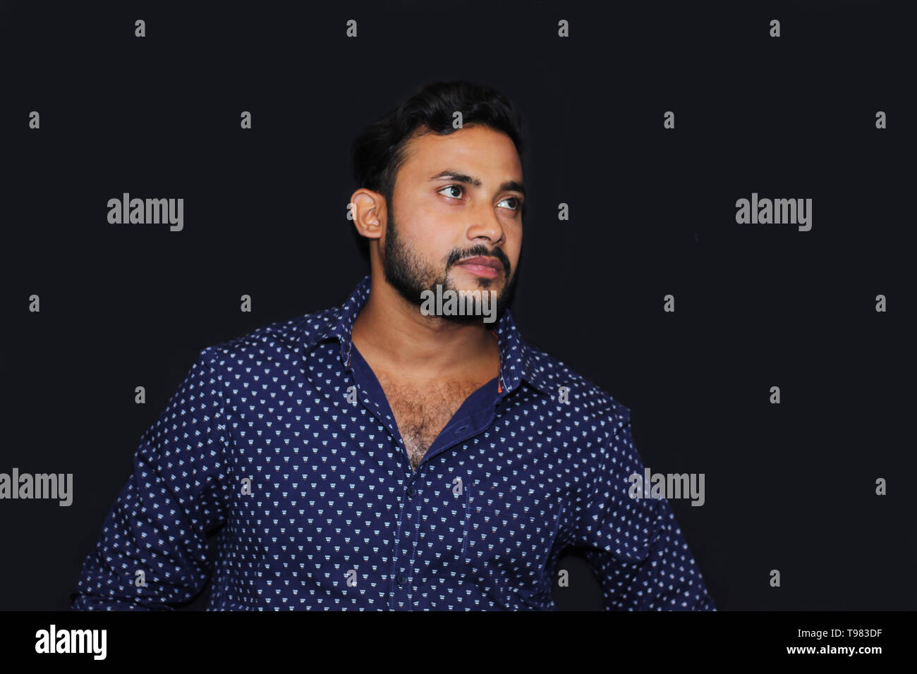 portrait of a young man model with black isolated background at studio ...