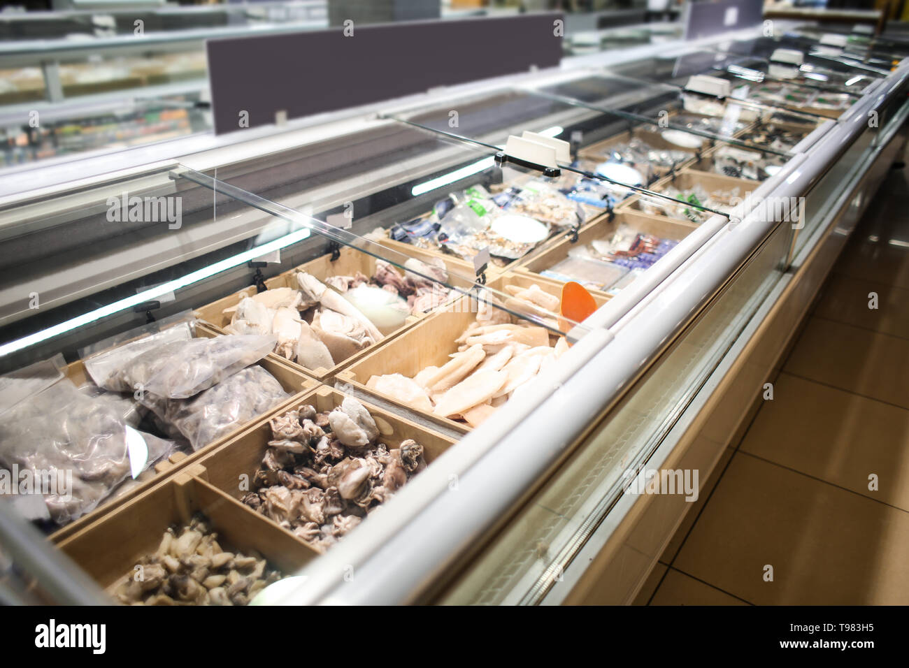 Refrigerator with assortment of frozen seafood in store Stock Photo - Alamy