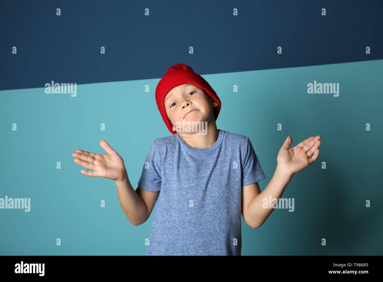 Emotional boy after making mistake on color background Stock Photo - Alamy