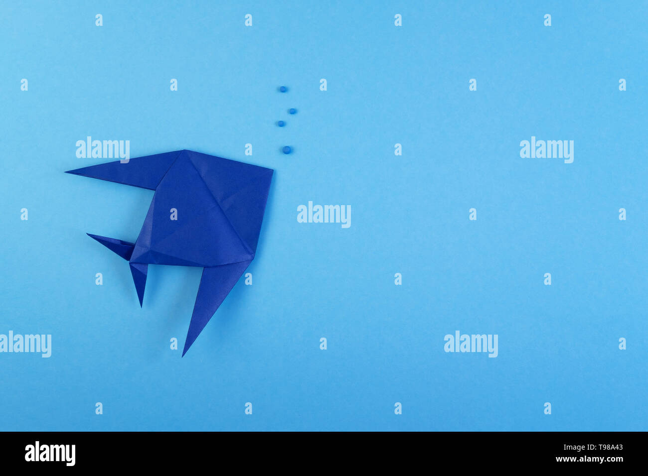 Origami tropical fish on sky blue minimalistic background. Paper sea ...
