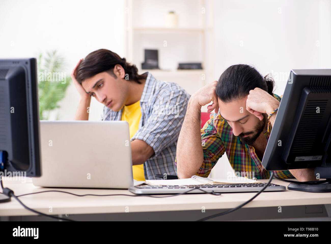 Two it specialists working in the office Stock Photo - Alamy