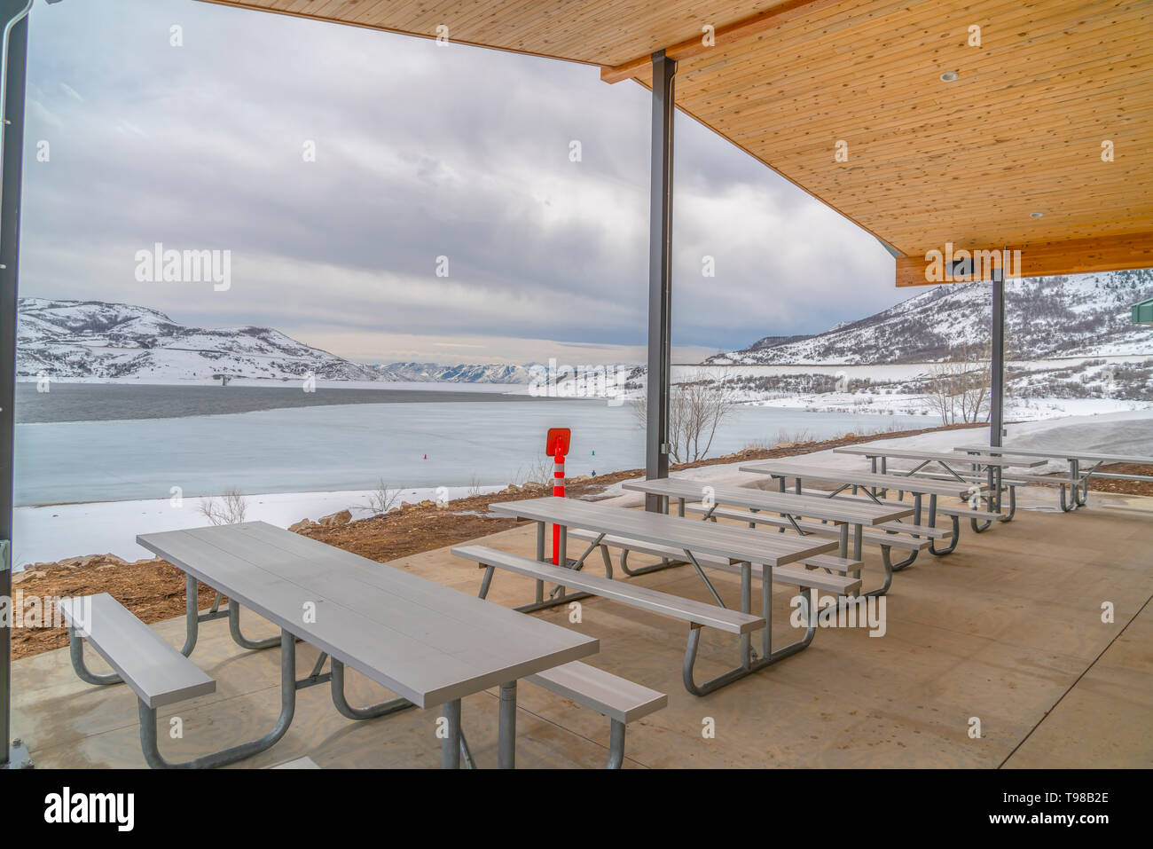 Eating area inside a pavilion overlooking a lake amid the snowy ...