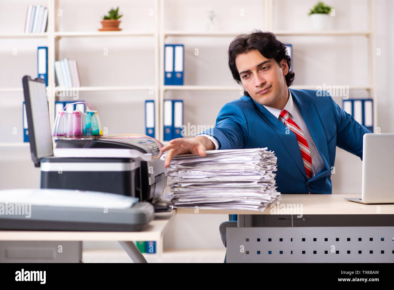 Young employee making copies at copying machine Stock Photo - Alamy