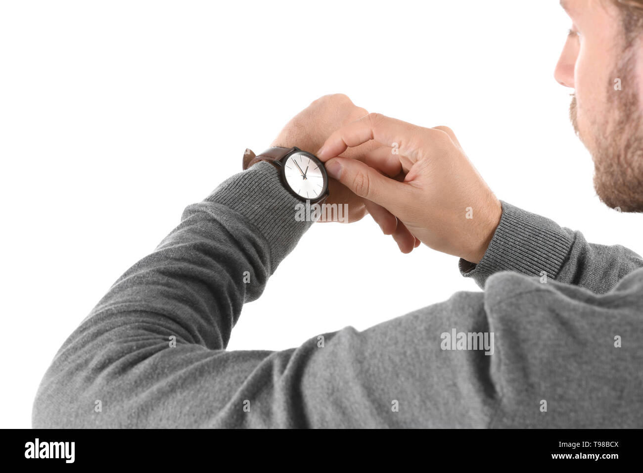 Young man looking at his watch on white background Stock Photo - Alamy