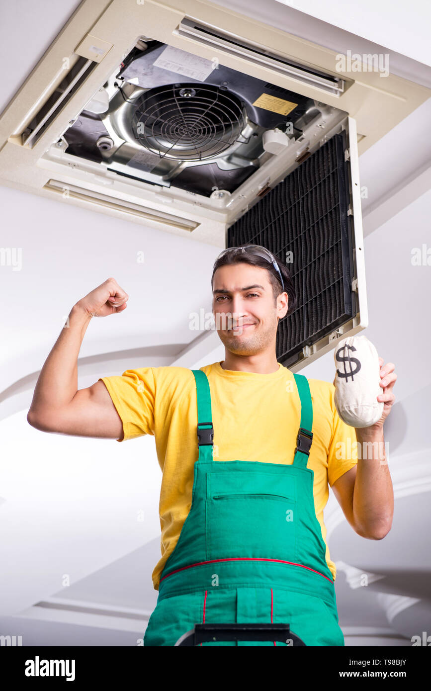 Young repairman repairing ceiling air conditioning unit Stock Photo - Alamy