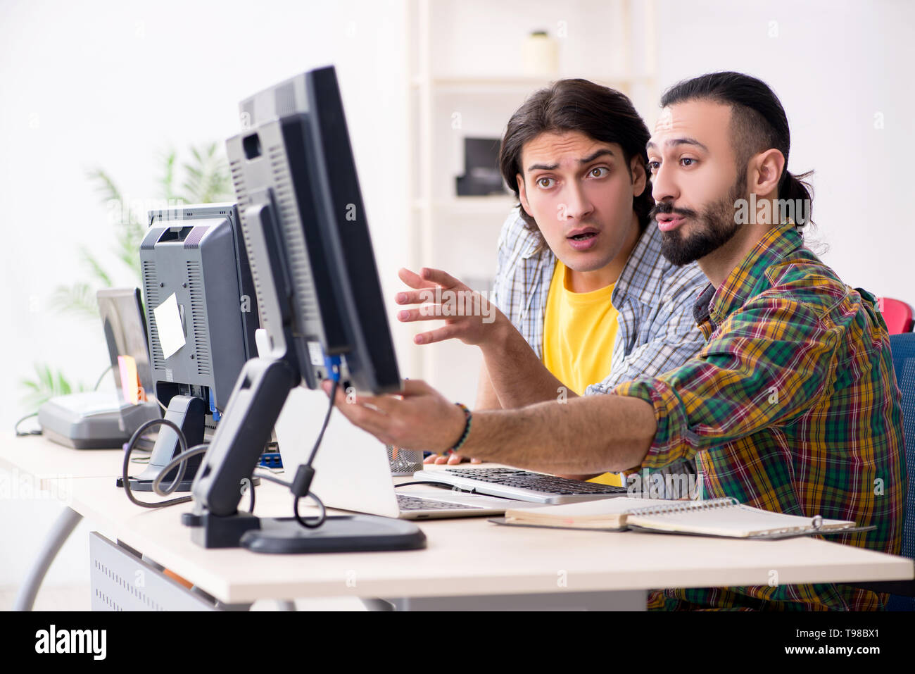 Two it specialists working in the office Stock Photo - Alamy