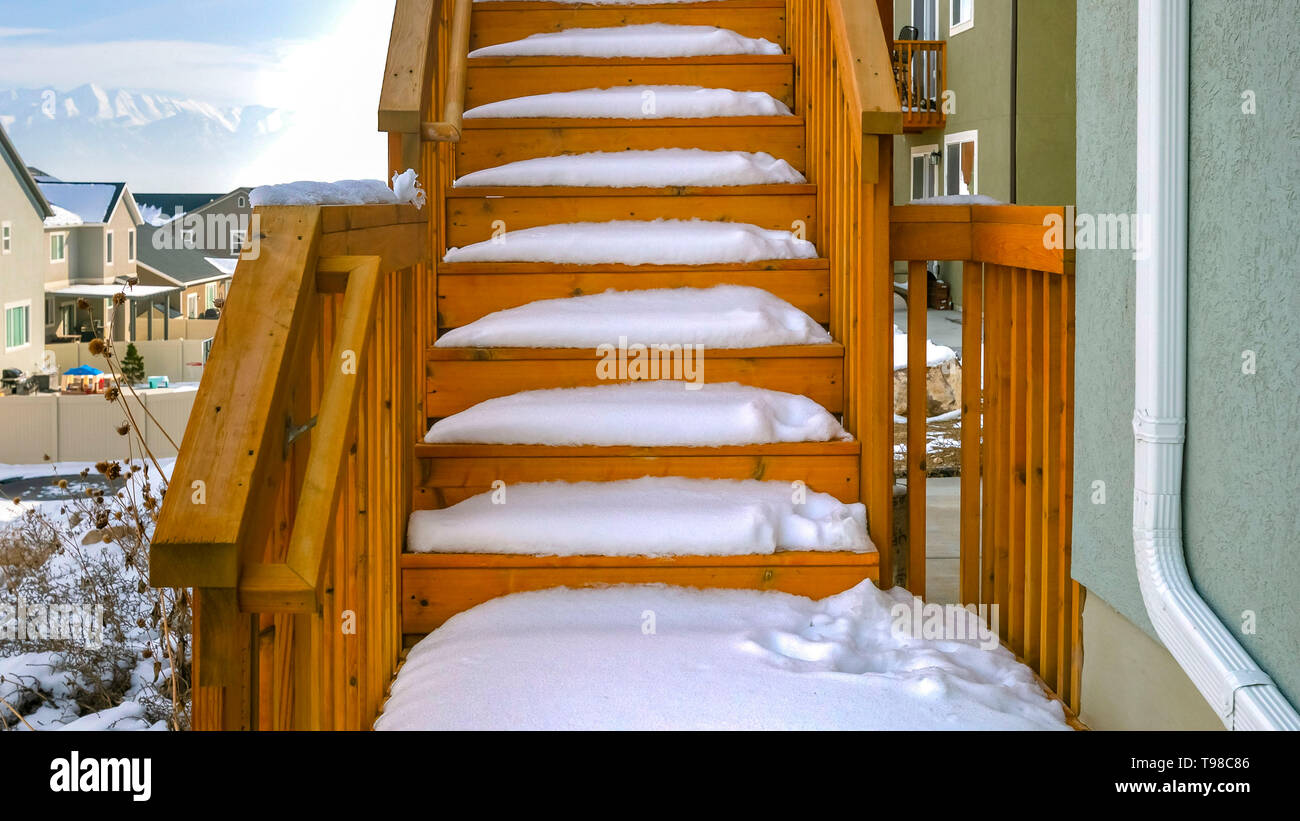 Clear Panorama Outdoor wooden staircase of a home covered with snow ...