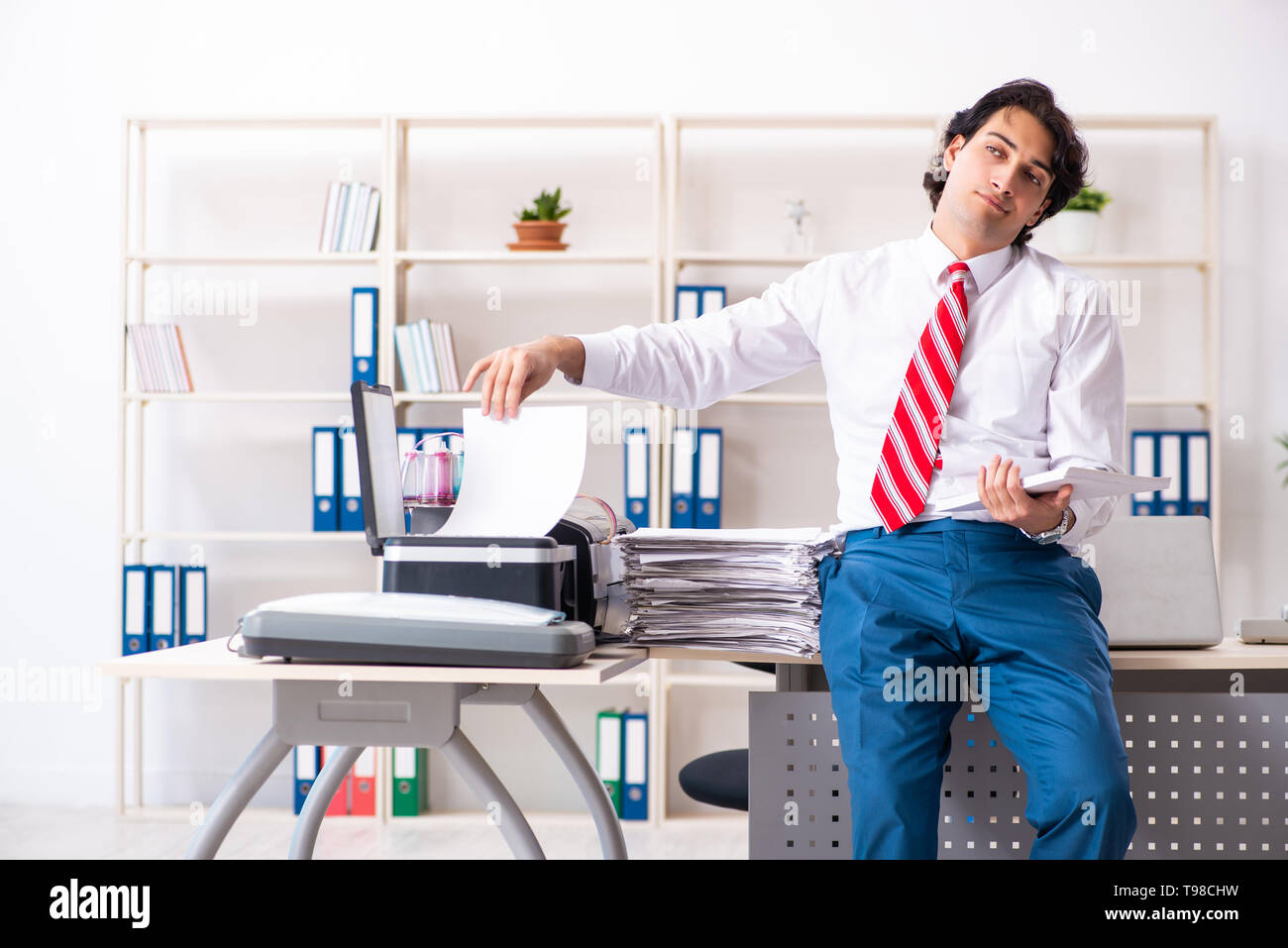 Young employee making copies at copying machine Stock Photo - Alamy
