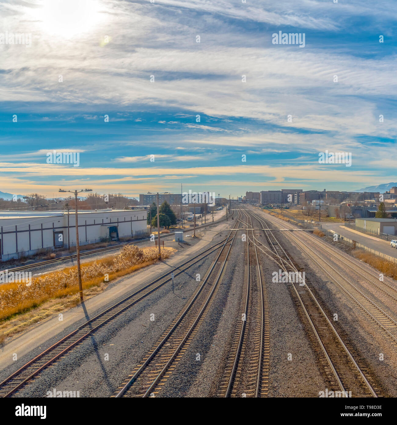 Square Railroad tracks and roads with mountain and vibrant cloudy blue ...