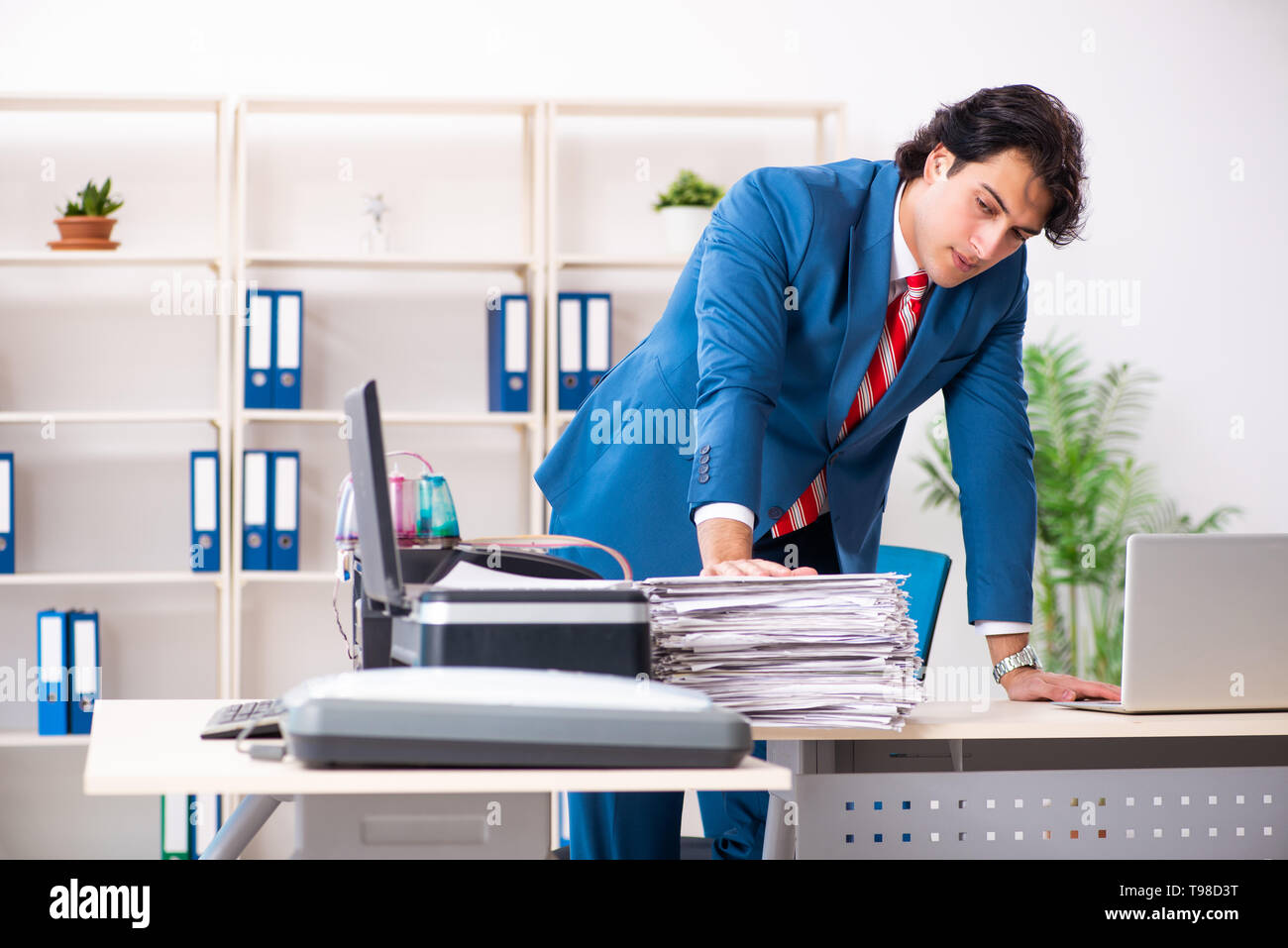 Young employee making copies at copying machine Stock Photo - Alamy