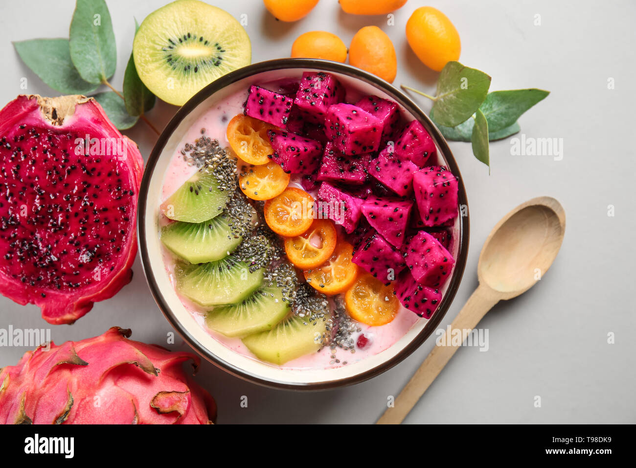 Yogurt with different fruits in bowl on light background Stock Photo ...