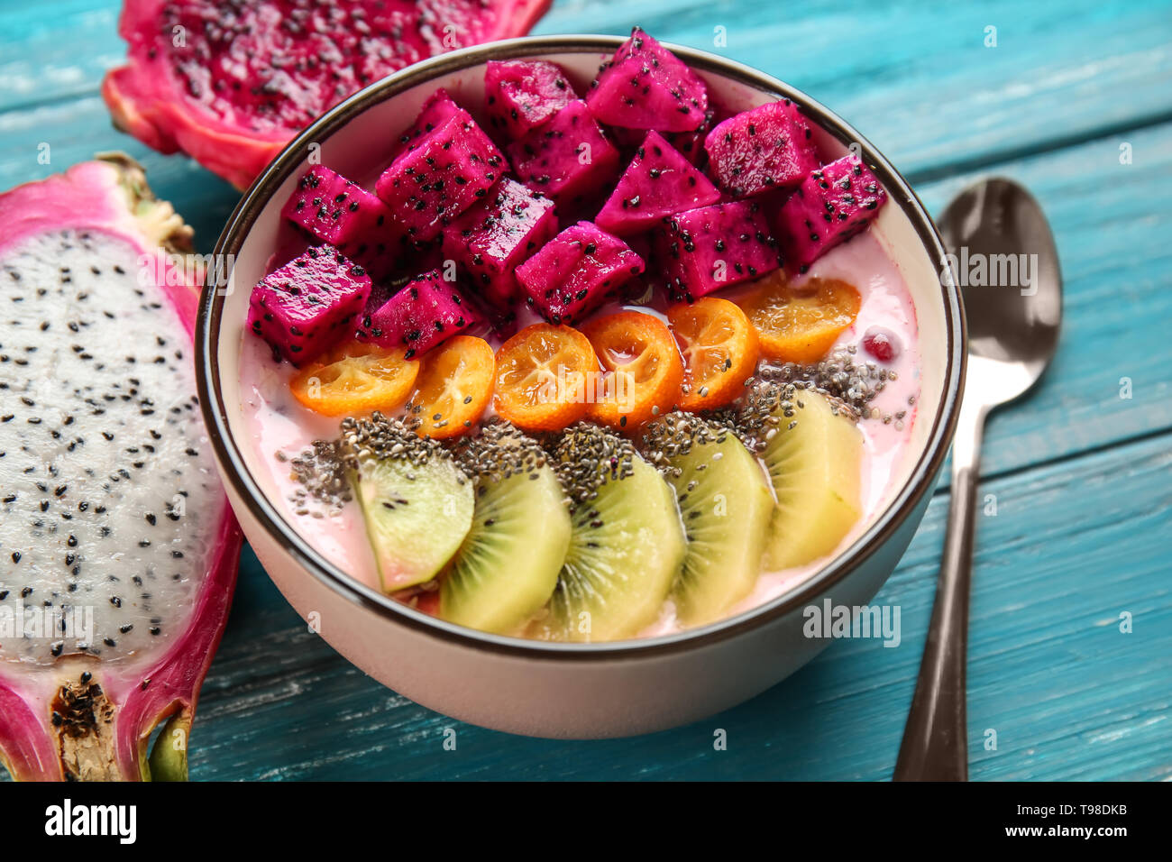 Yogurt with different fruits in bowl on wooden background Stock Photo ...