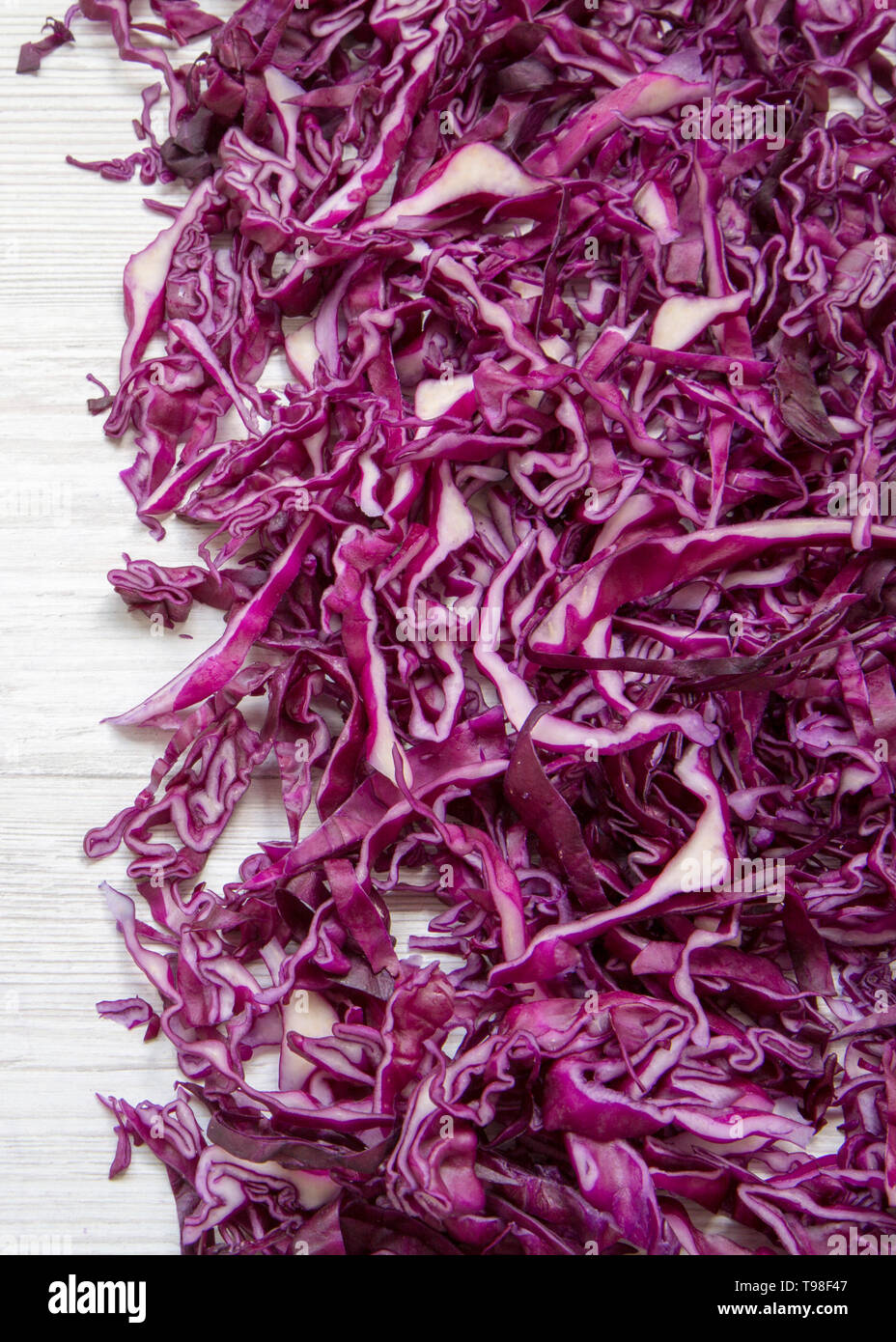 Chopped red cabbage on a white wooden background, close-up. Top view ...