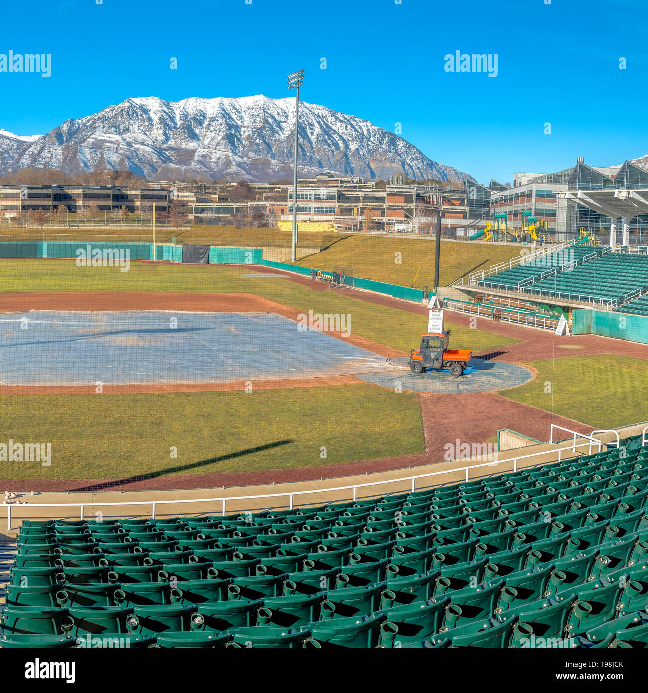 Clear Square Baseball field with green tiered seating against mountain ...
