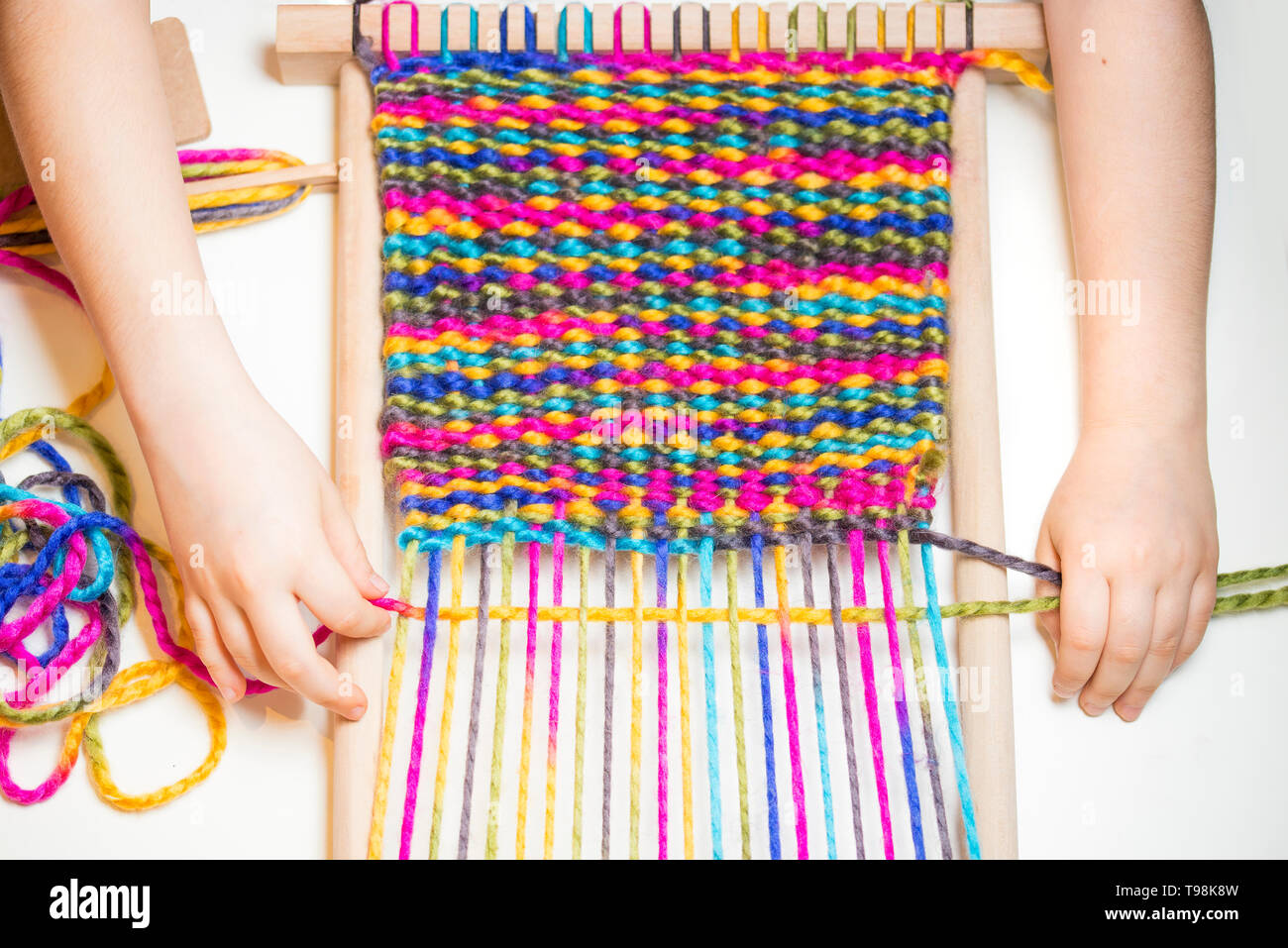 Weaving. Hands of little caucasian girl working on small loom weaving ...