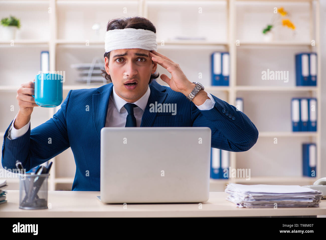 Head injured male employee working in the office Stock Photo - Alamy