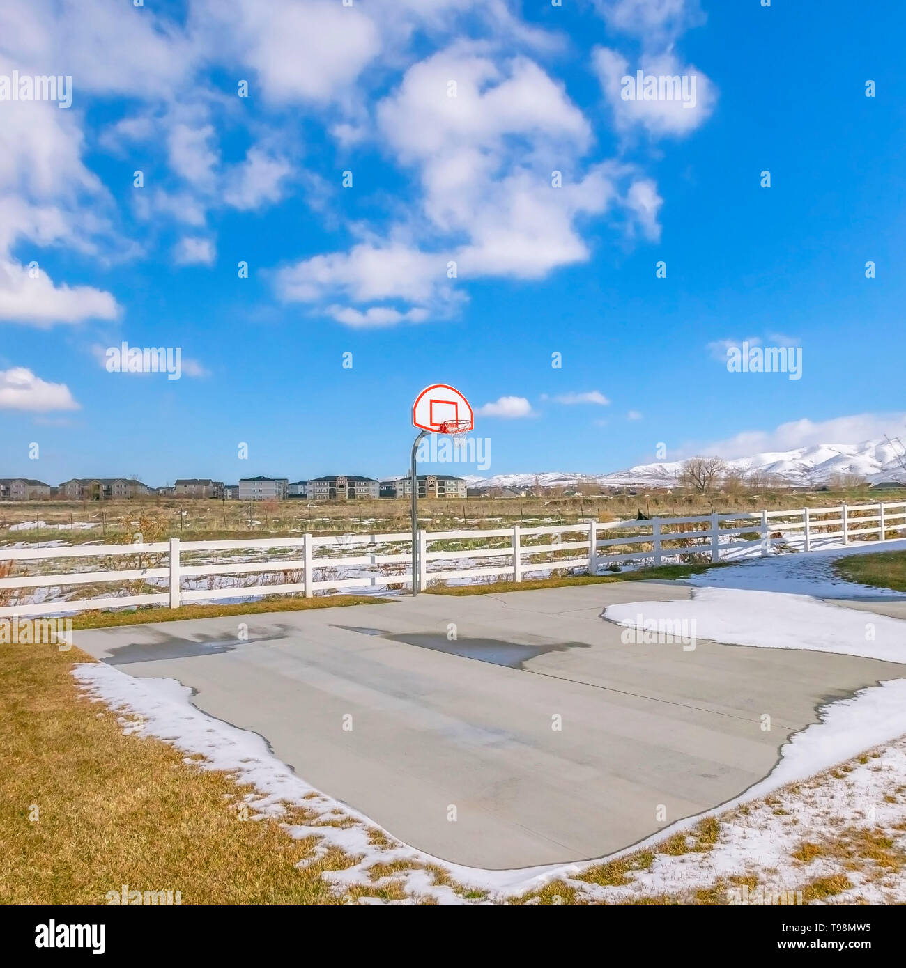 Clear Square Basketball court surrounded by a snowy and grassy terrain ...