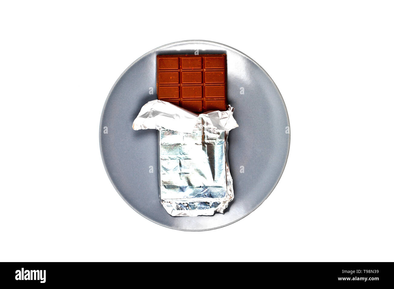Chocolate bar with foil on grey ceramic plate isolated on white ...