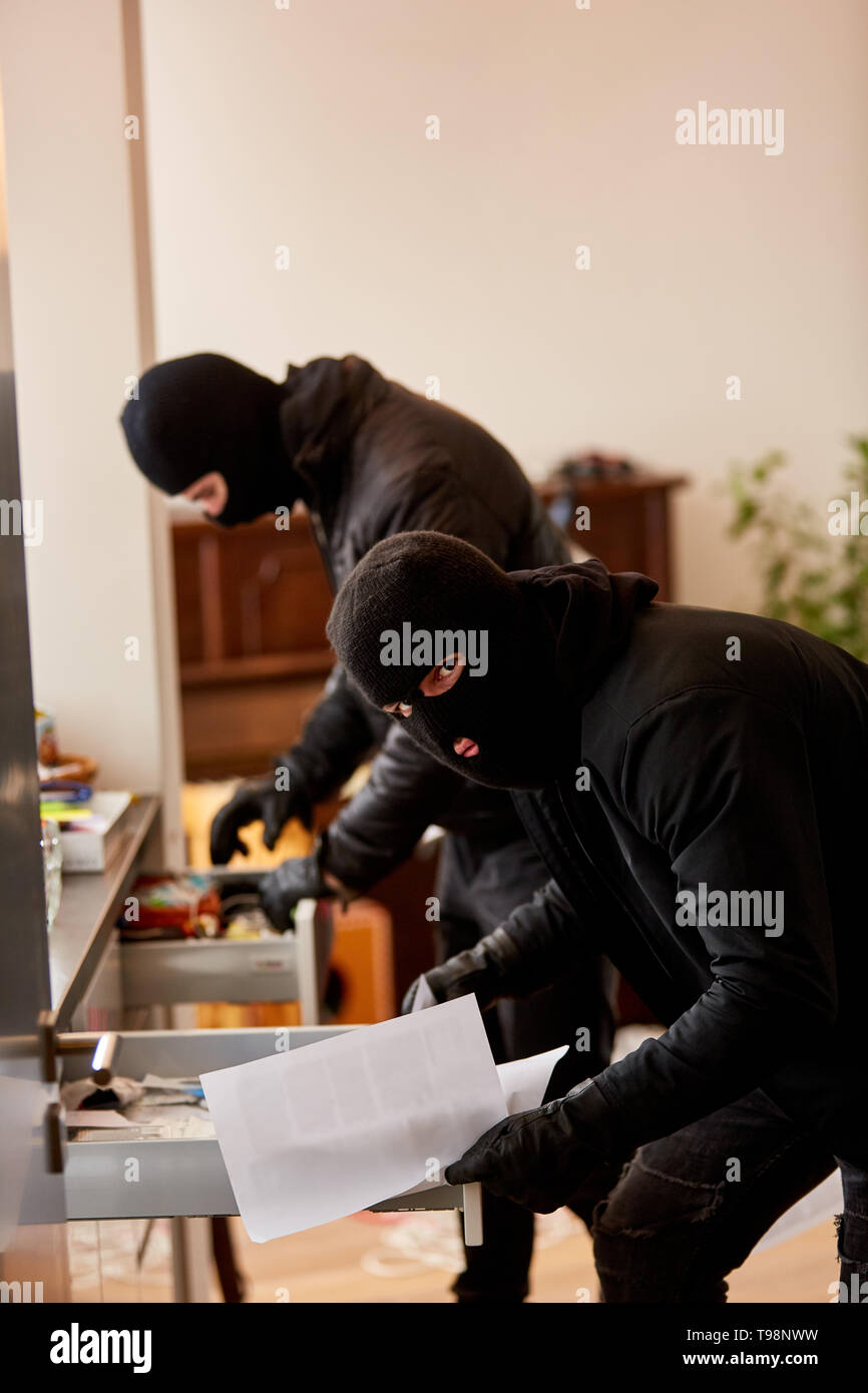 Two burglars browse drawers in the house during a burglary Stock Photo ...