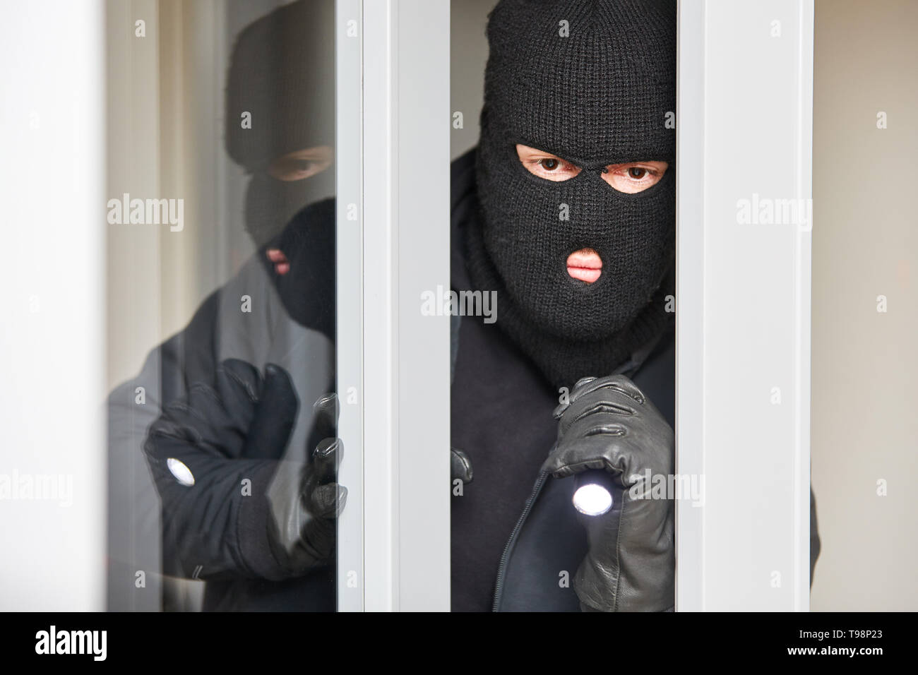 Man as burglar or thief with balaclava and flashlight Stock Photo - Alamy