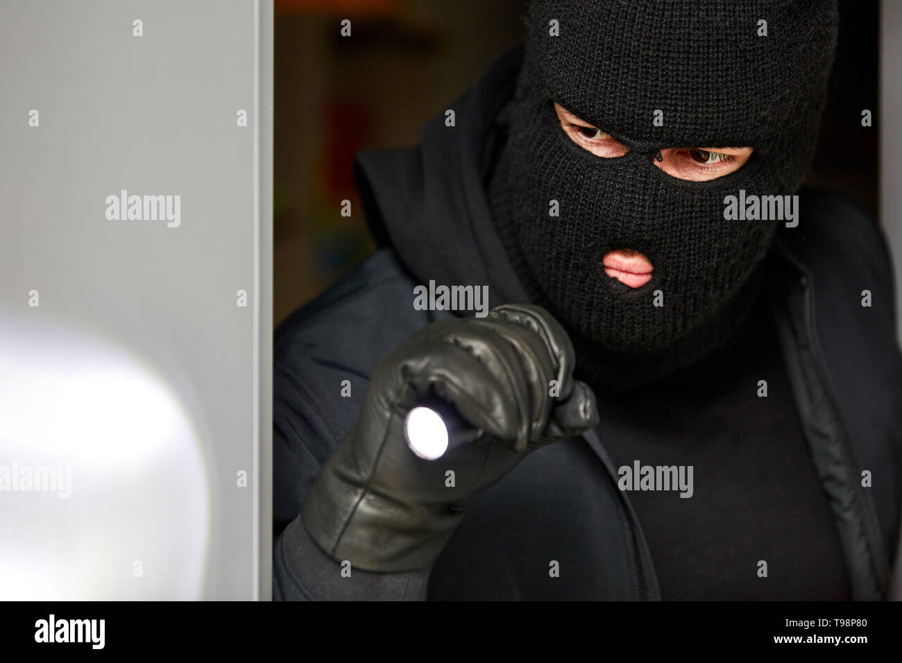 Burglar breaking in at night in house with flashlight Stock Photo - Alamy