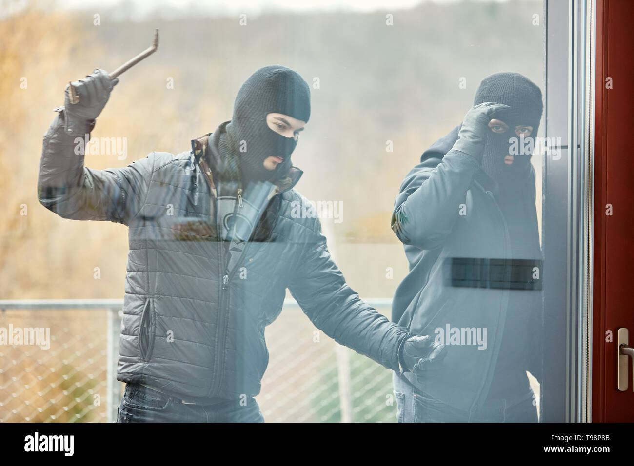 Burglars with crowbars hit windows in the house during burglary Stock ...