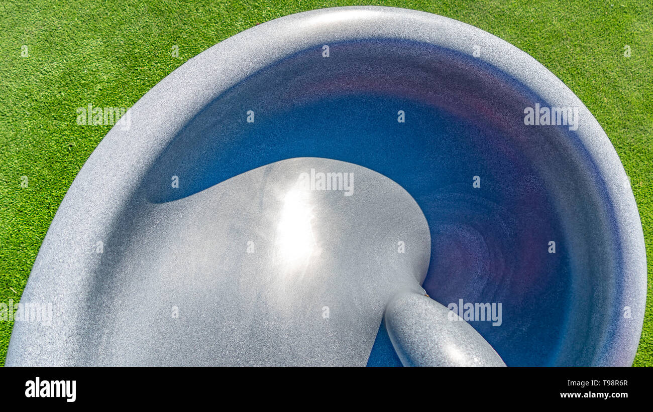 Clear Panorama Looking down at a shiny gray slide of a playground on a ...
