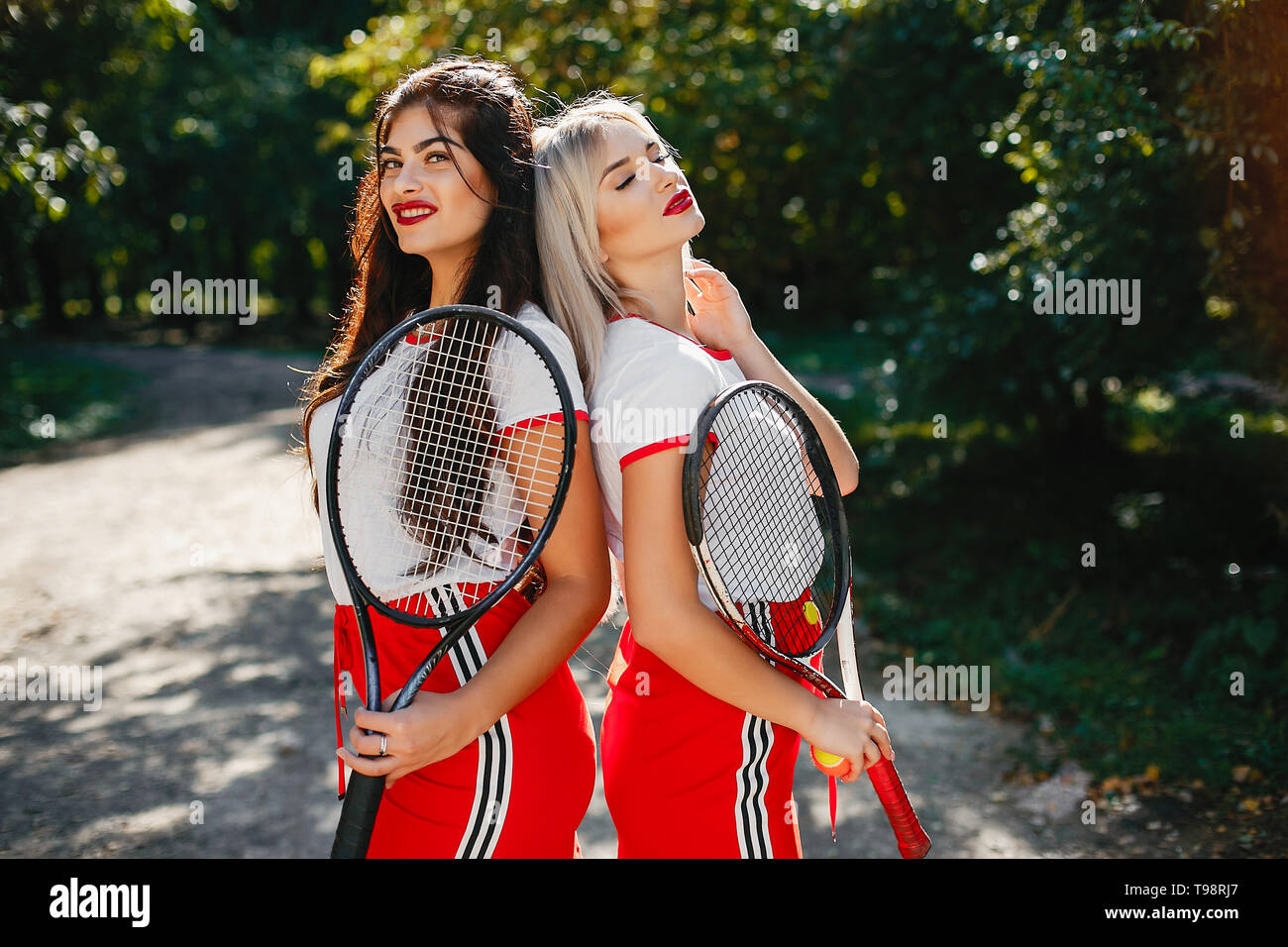 Girls in a summer park. Stylish ladies in a sports clothes Stock Photo ...