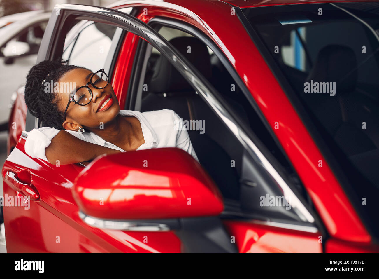 Stylish black woman in a car salon Stock Photo - Alamy